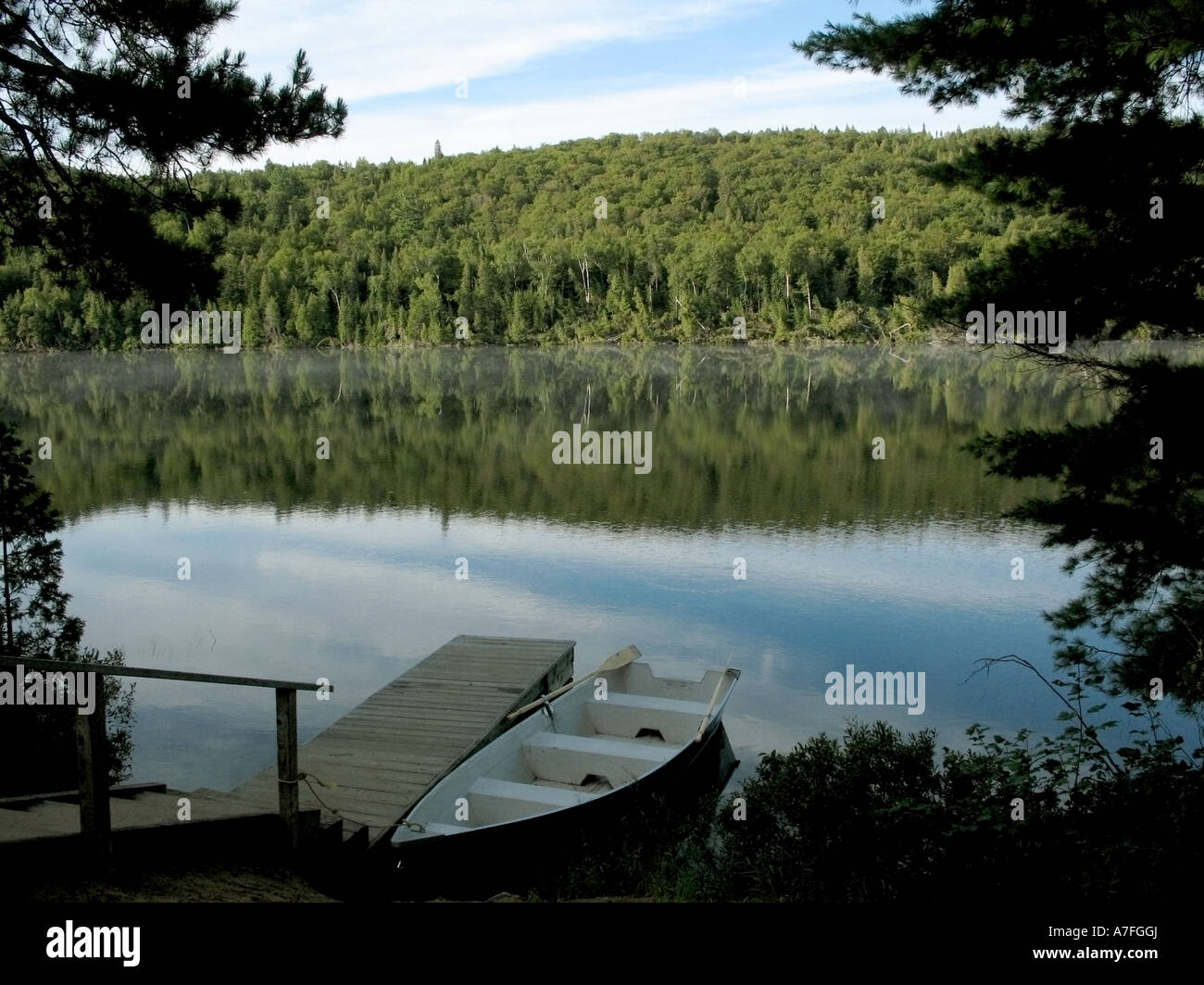 Row boat at small dock on lake Stock Photo - Alamy