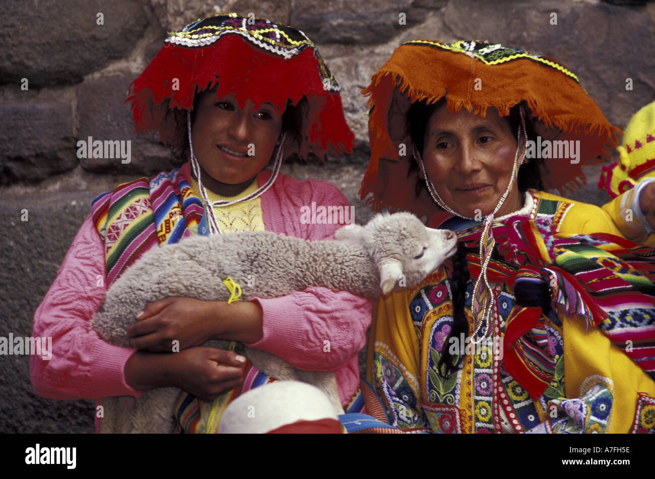 South America, Peru. Peruvian women in traditional dress holding lamb ...