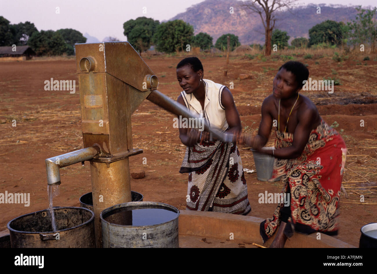 Africa.Mozambique. Collecting water two women using a hand pump Stock ...