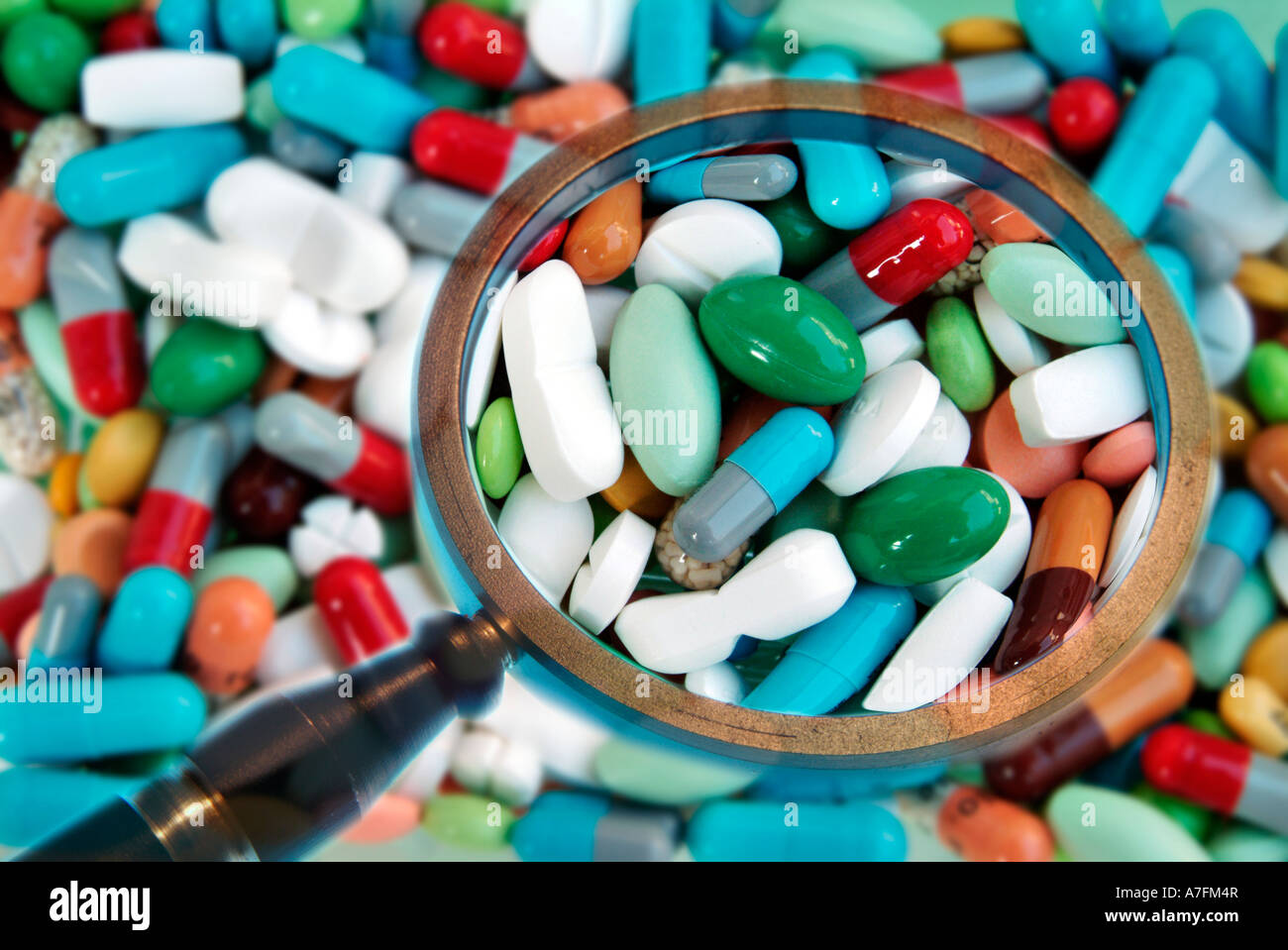 medicin in different coloured pills with a magnifying glass Stock Photo ...