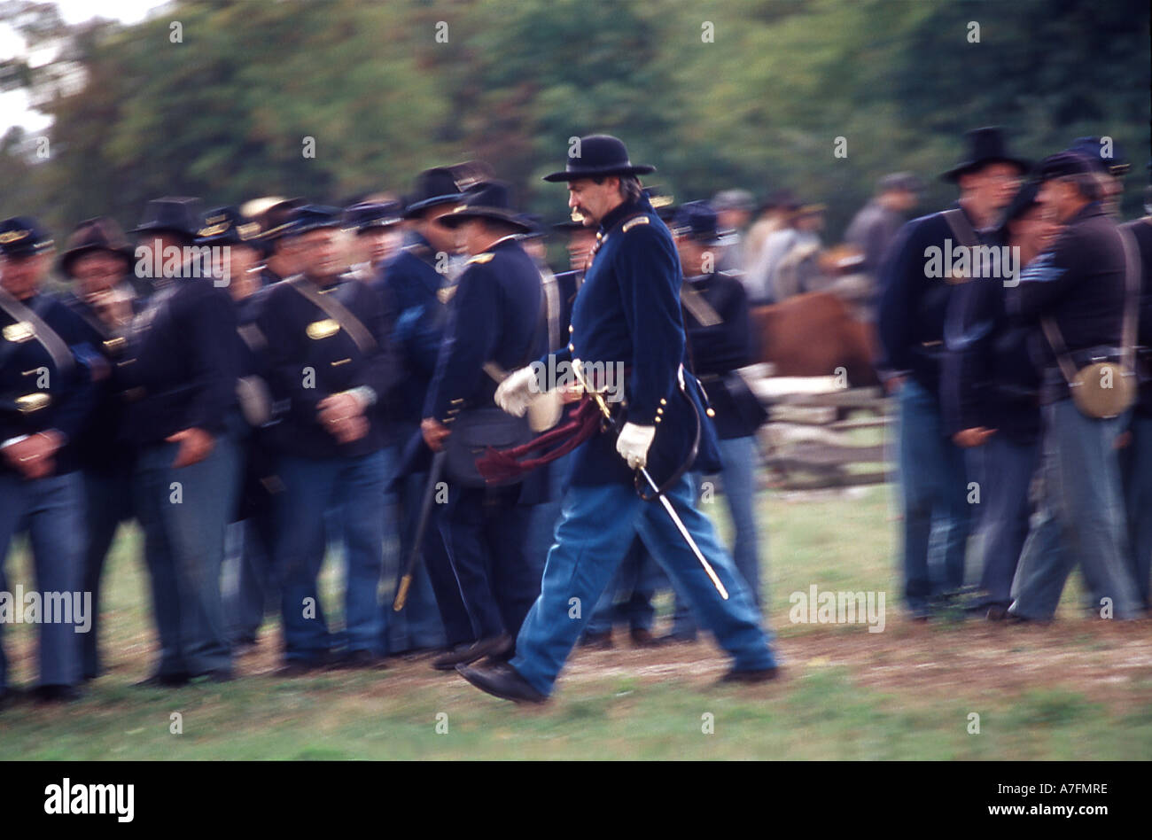 One Union soldier walking quickly past a group of soldiers at a Civil ...