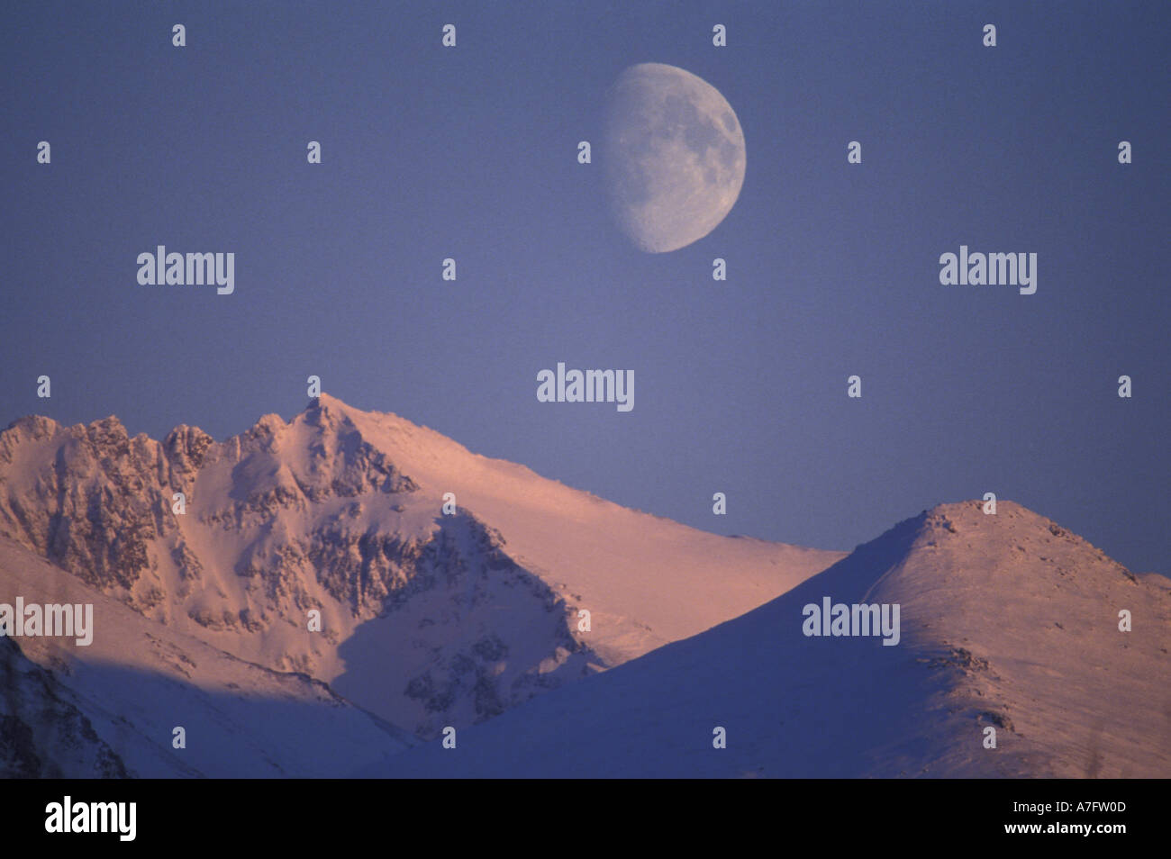 Alaska, Anchorage Full moon rises behind Chugach Mountains Range Stock ...