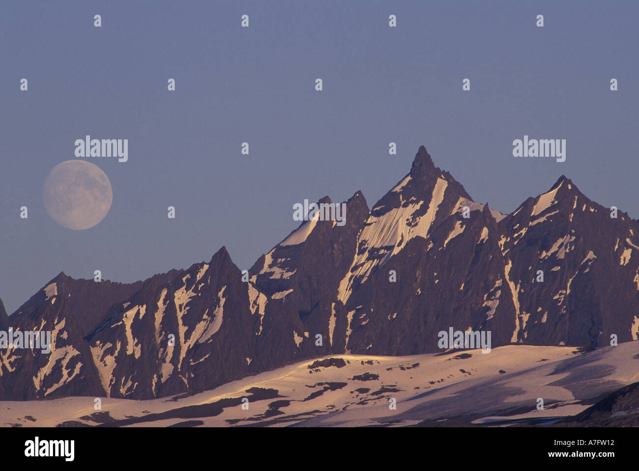 USA, Alaska, Valdez Moon rises above rugged Chugach Range mountains ...