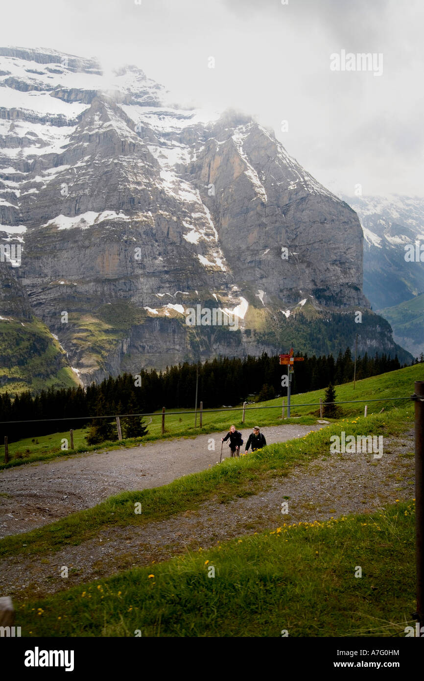 Hikers walk the gentle path from Kleine Scheidigg down to Wengen past ...