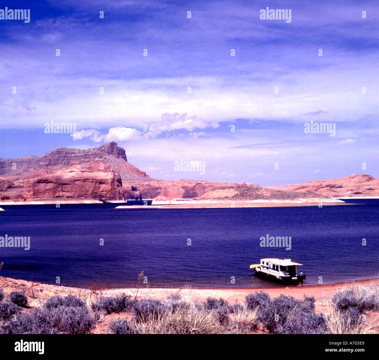 Houseboat moored in a quiet bay on Lake Powell Reservoir which covers ...