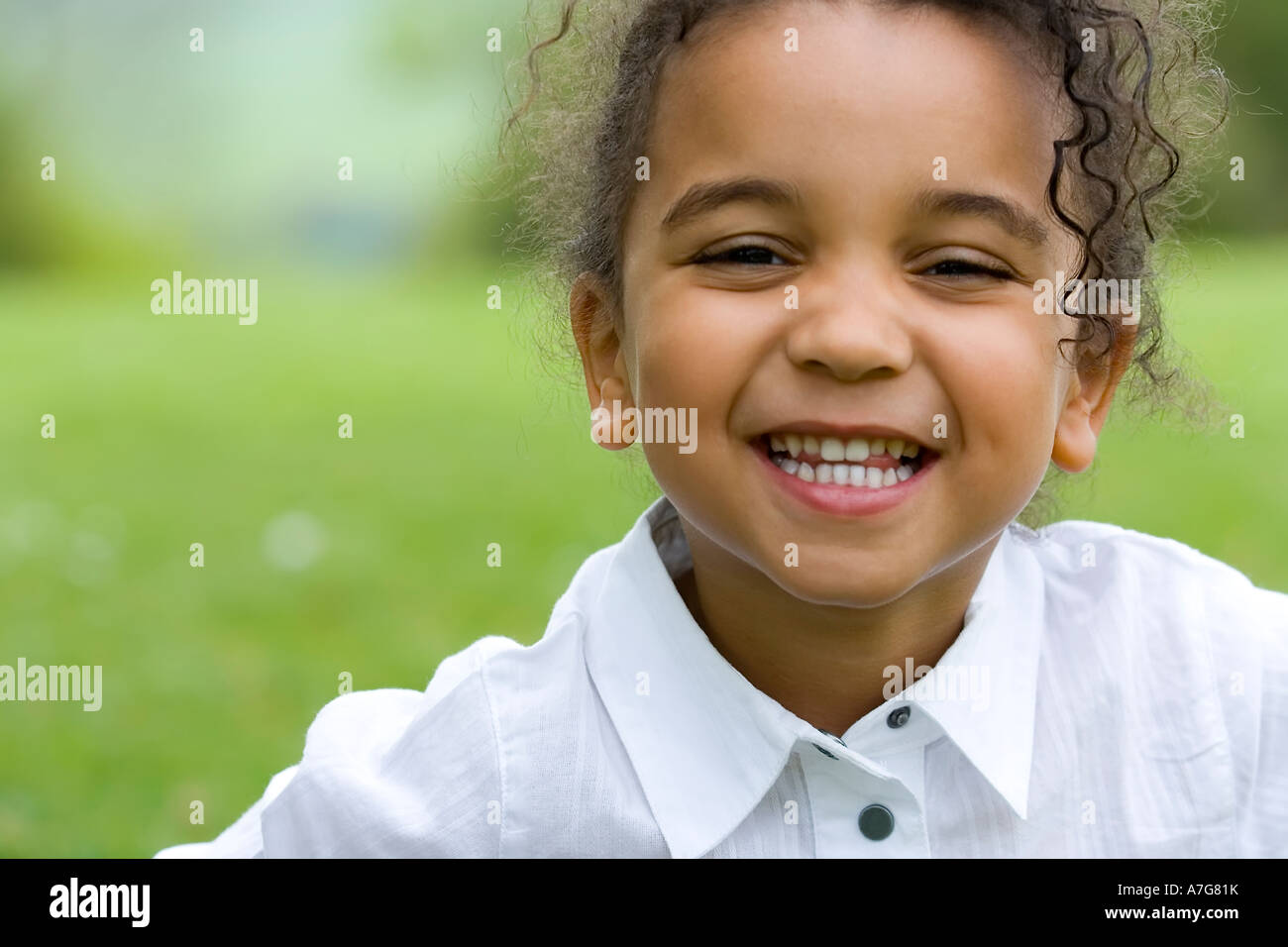 A beautiful mixed race little girl smiles sweetly for the camera Stock ...