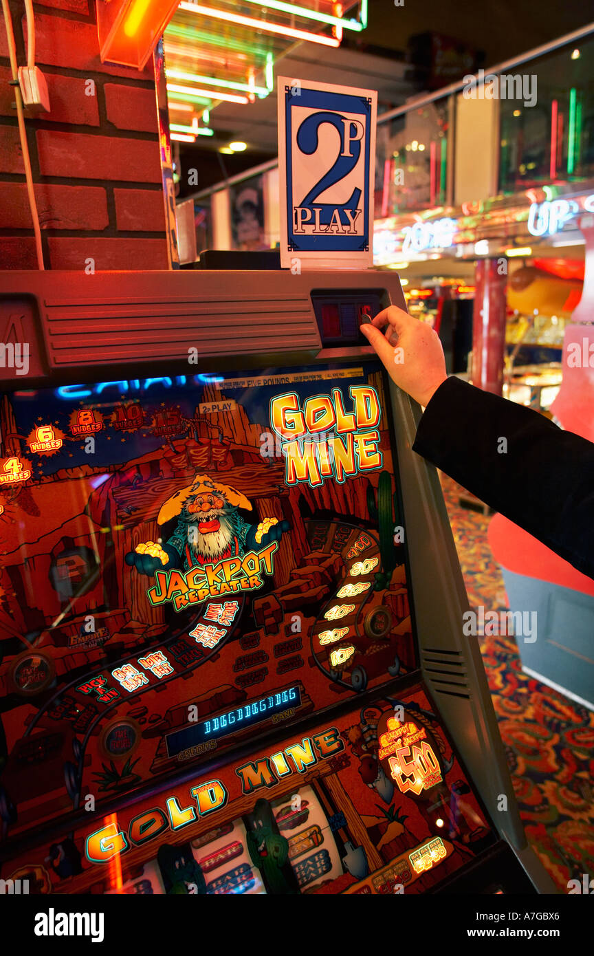 Playing a penny fruit machine in a seaside amusement arcade, UK Stock ...