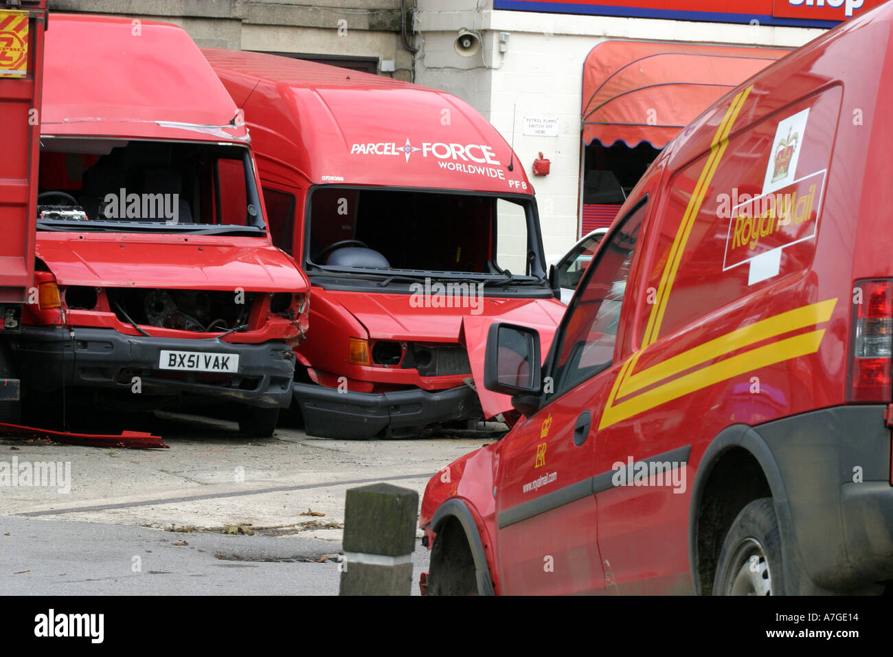 Accident damaged Royal Mail and Post Office vans on a garage forecourt ...