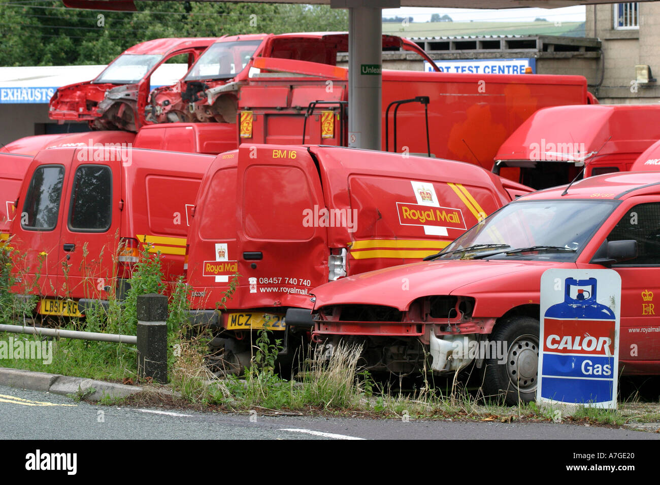 Accident damaged Royal Mail and Post Office vans on a garage forecourt ...
