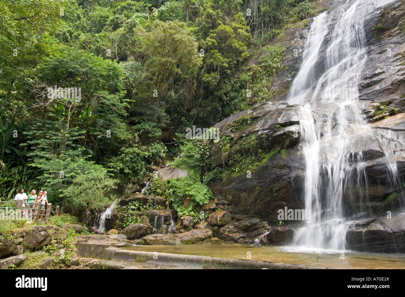 Tourists enjoy a waterfall and scenery of the Tijuca National Park in ...