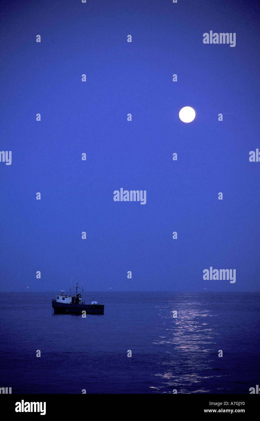 Moonrise over the Pacific Ocean and a harbored boat; Santa Barbara ...
