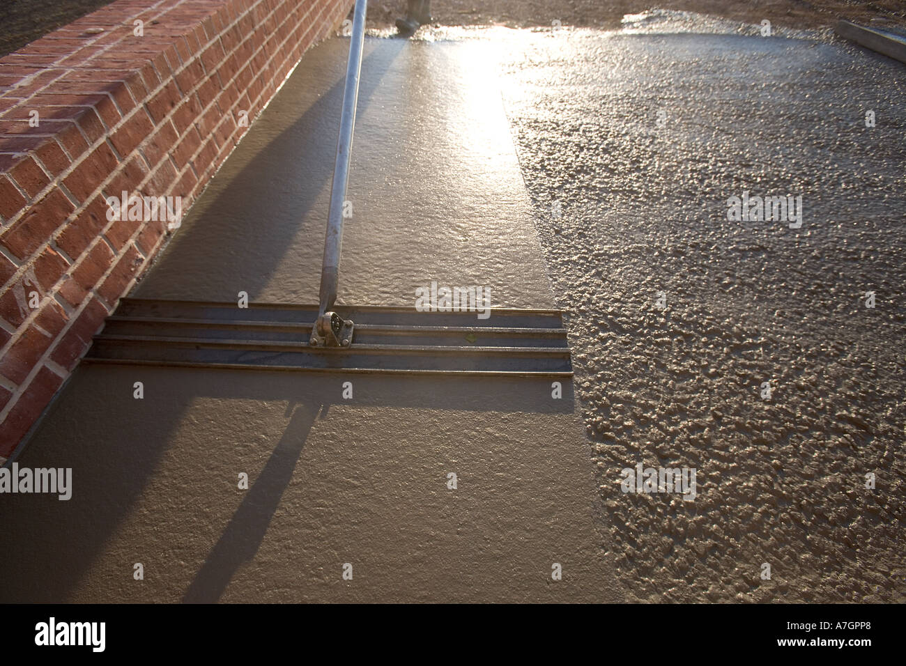 Smoothing wet cement for a driveway Stock Photo - Alamy