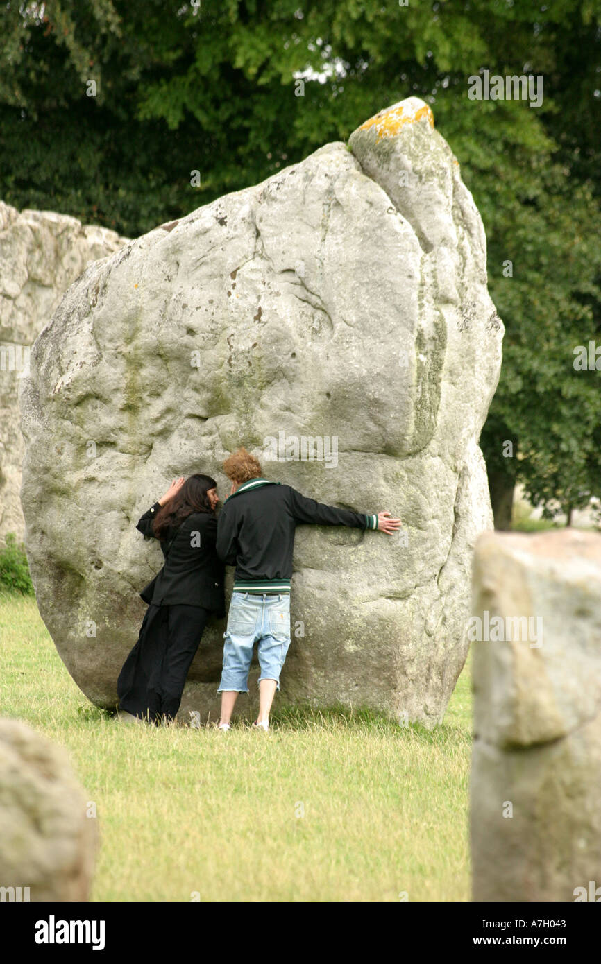 Young couple hugging the ancient neolithic stones at Avebury Wilthsire ...