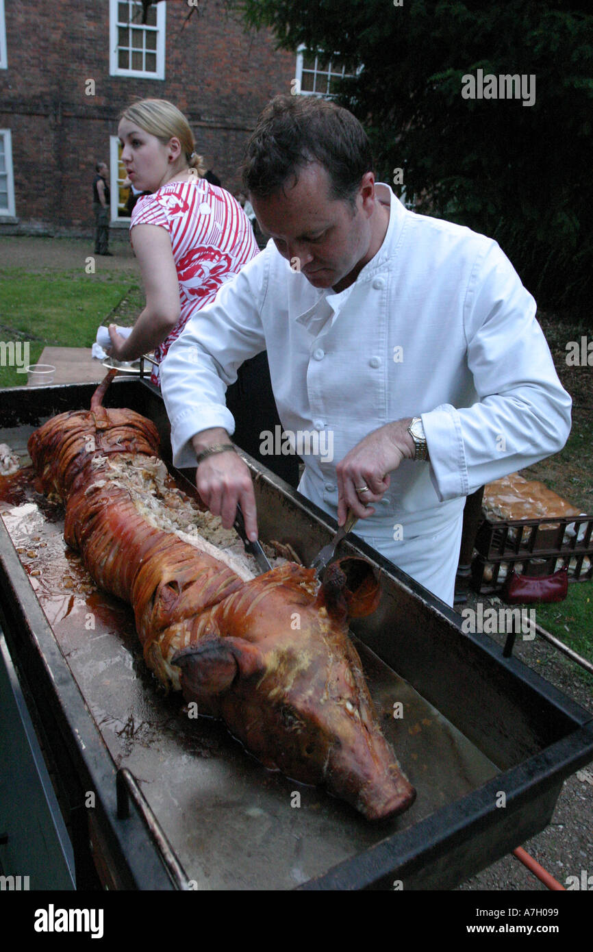 A chef carving at a pig roast Stock Photo - Alamy