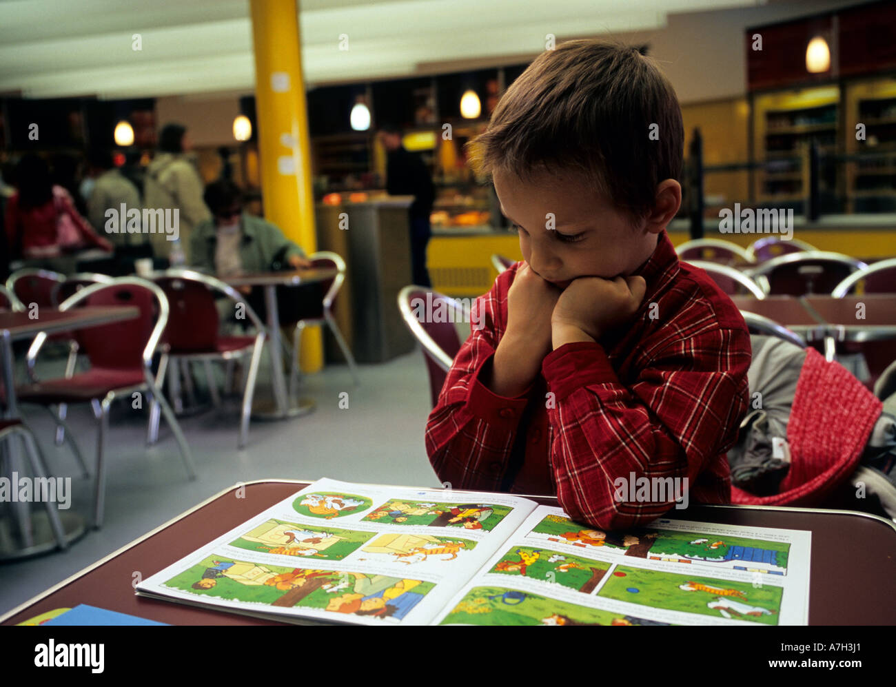 Boy reading cartoon comics in a waiting room Stock Photo - Alamy