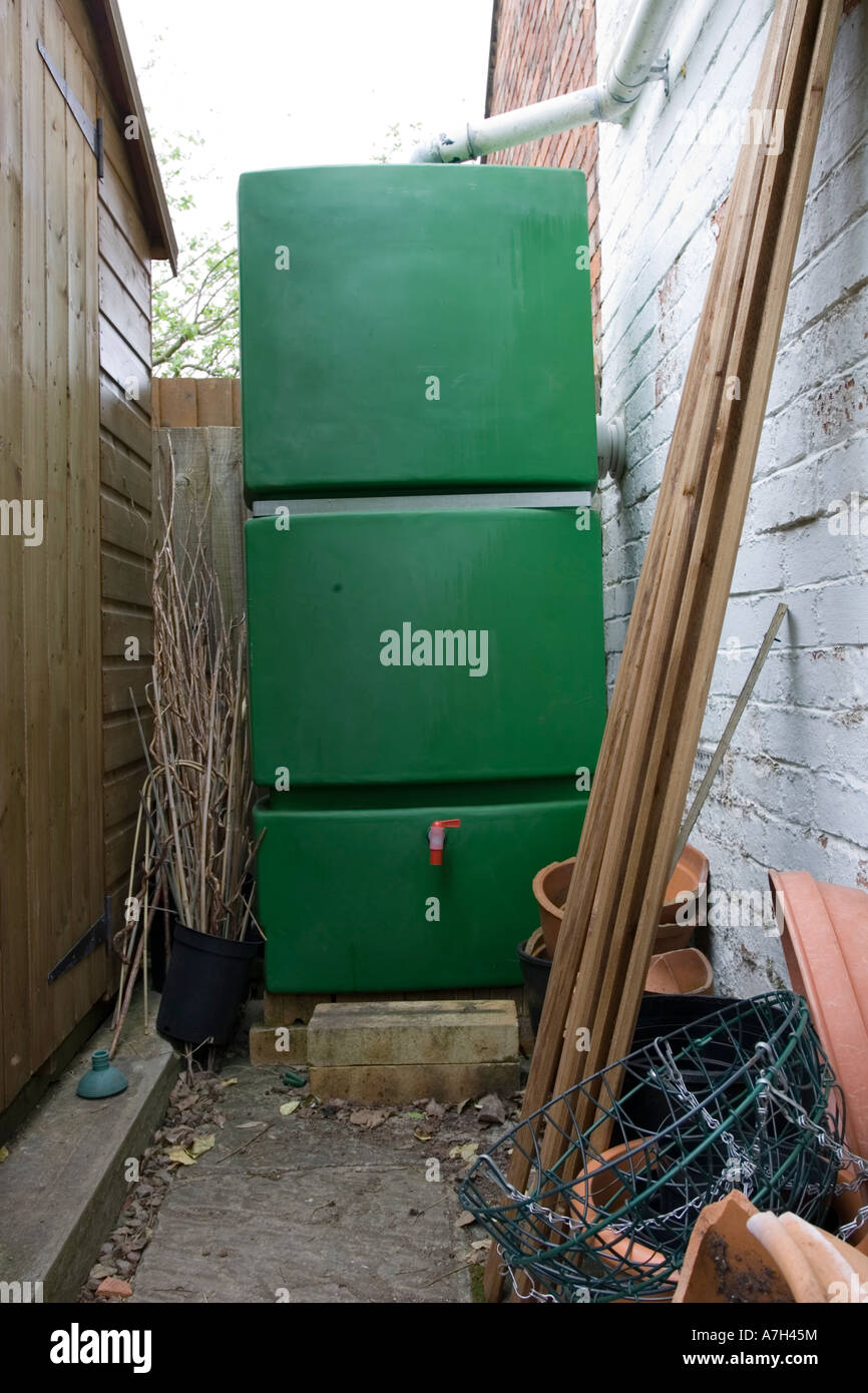 Large green plastic water storage tank collecting rainwater from roof ...