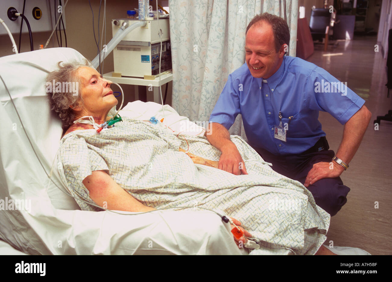 Hospital chaplain comforting elderly patient on ward Stock Photo - Alamy