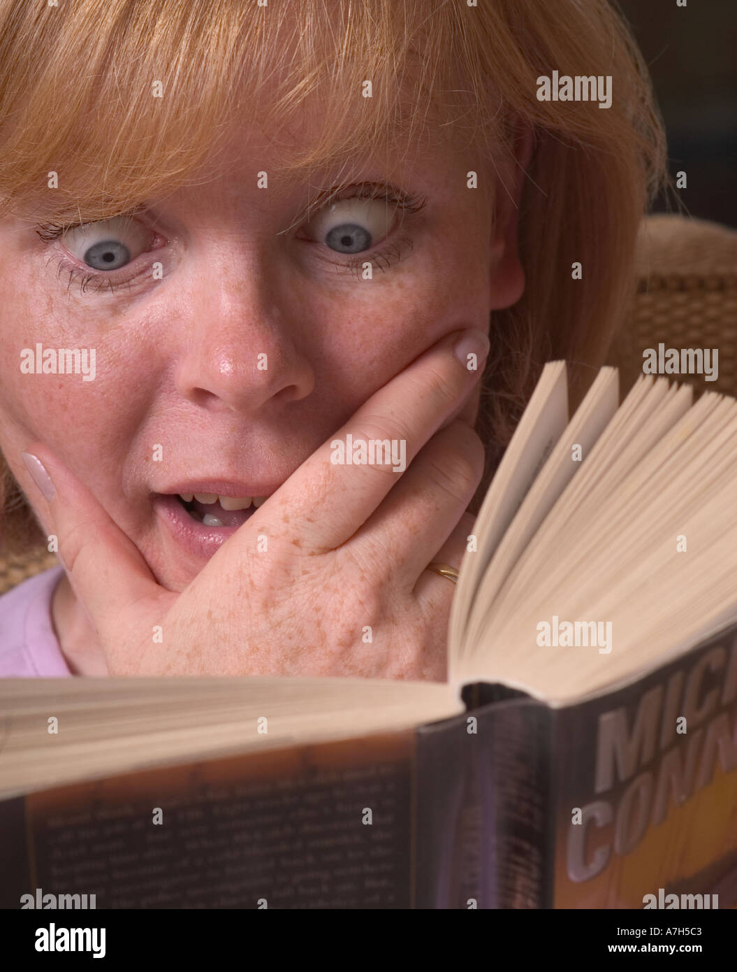 woman looks shocked reading a book Stock Photo - Alamy
