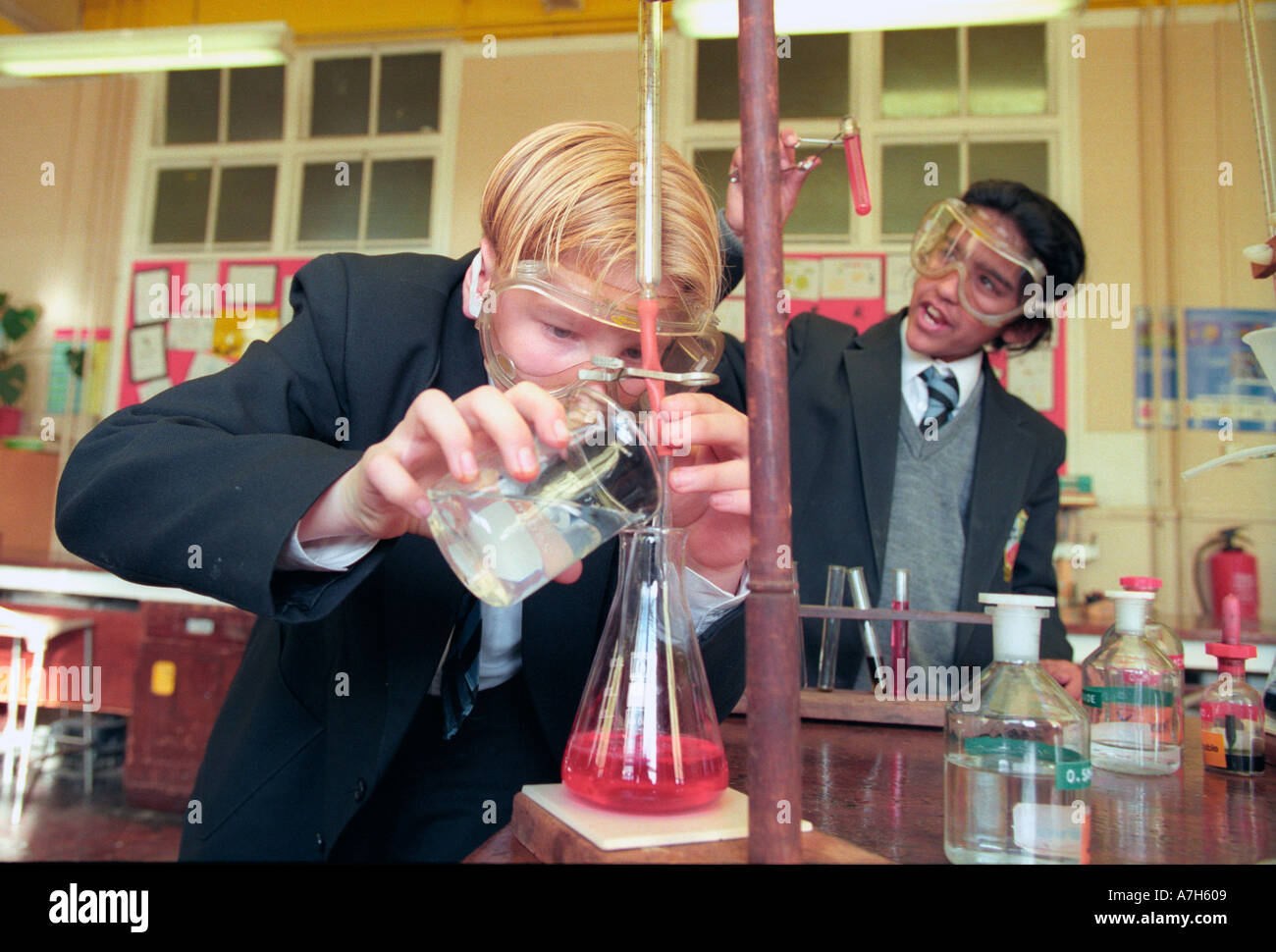Secondary school pupils working on science experiments in classroom ...