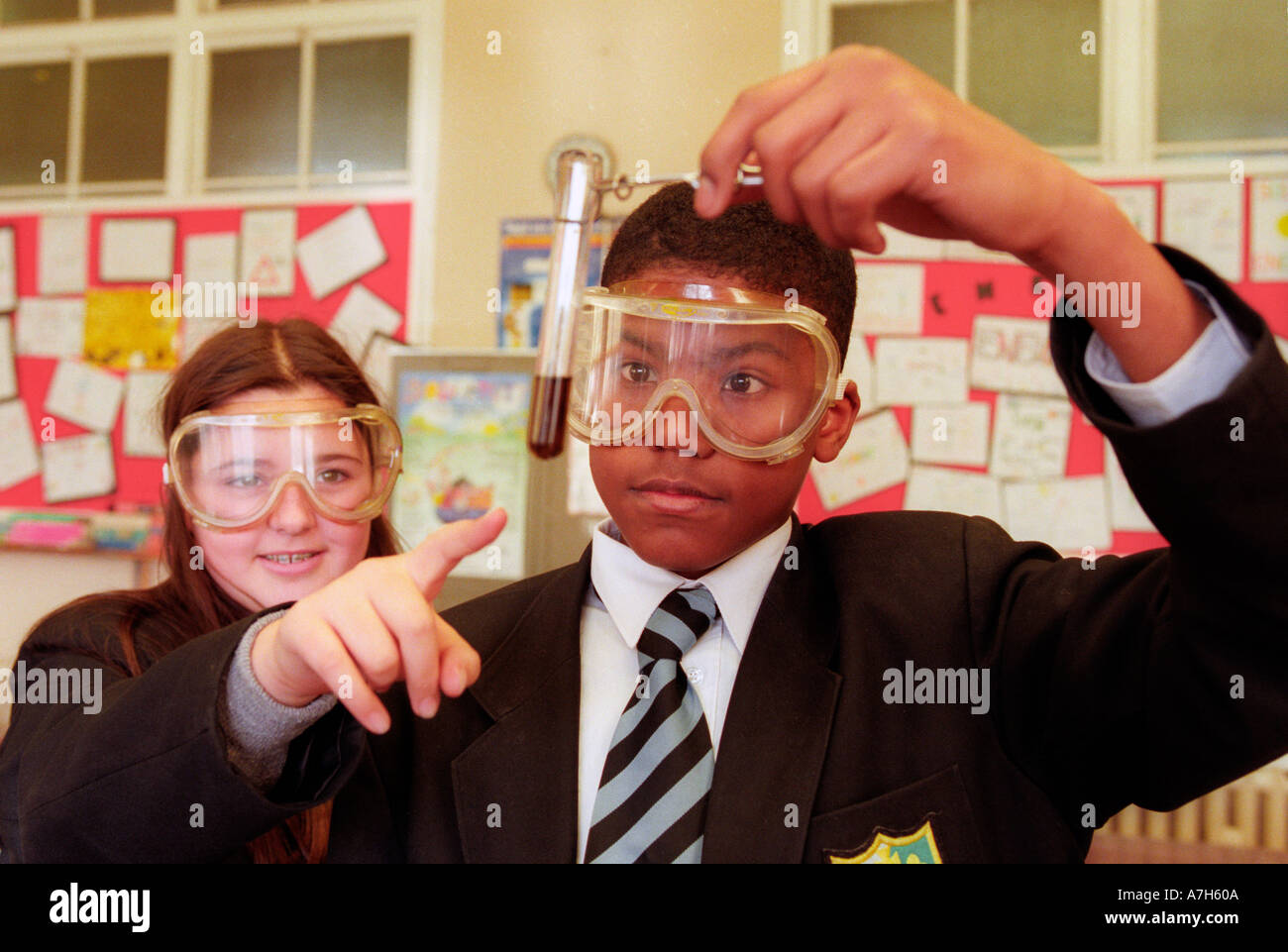 Secondary school pupils working on science experiments in classroom ...