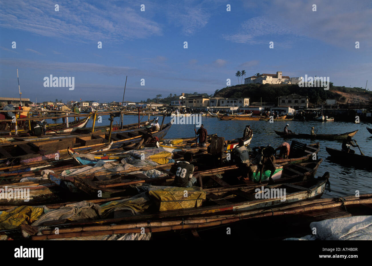 Fishing pirogues in the harbour with Fort St Jago on the hill, Elmina ...