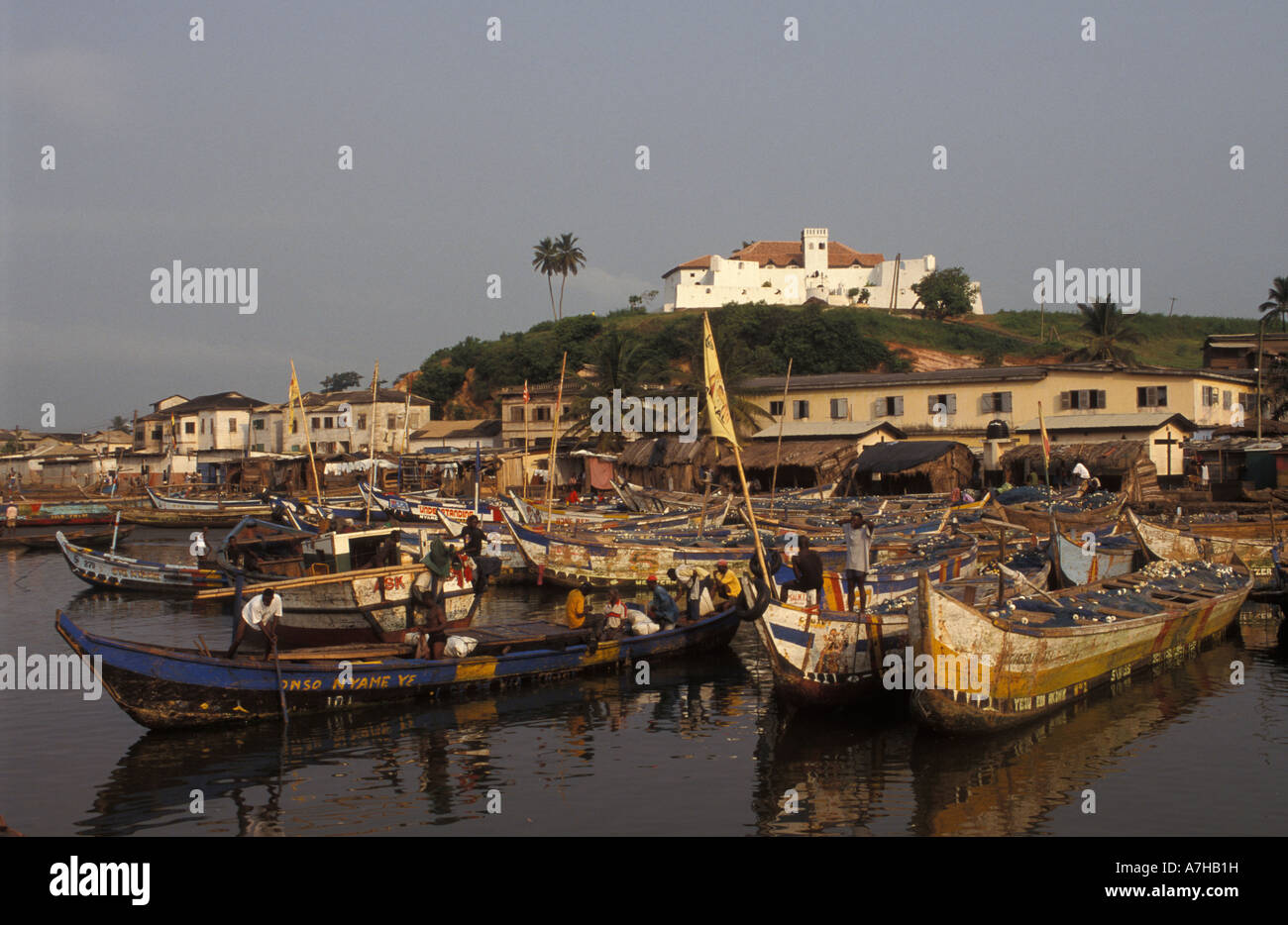 Fishing pirogues in the harbour with Fort St Jago on the hill, Elmina ...