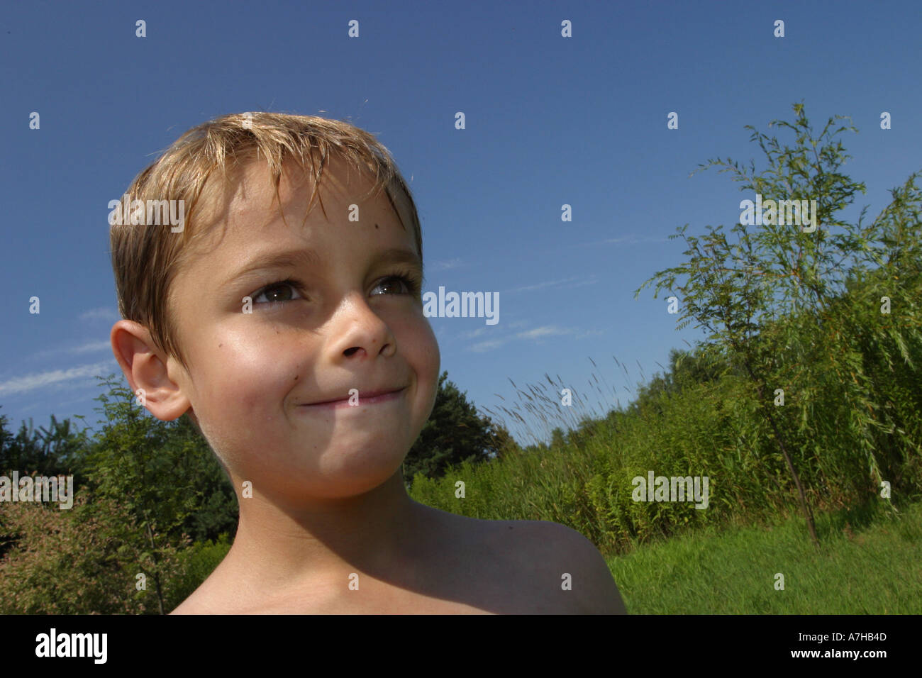 Young boy looking happy gazing on a summers day Stock Photo - Alamy