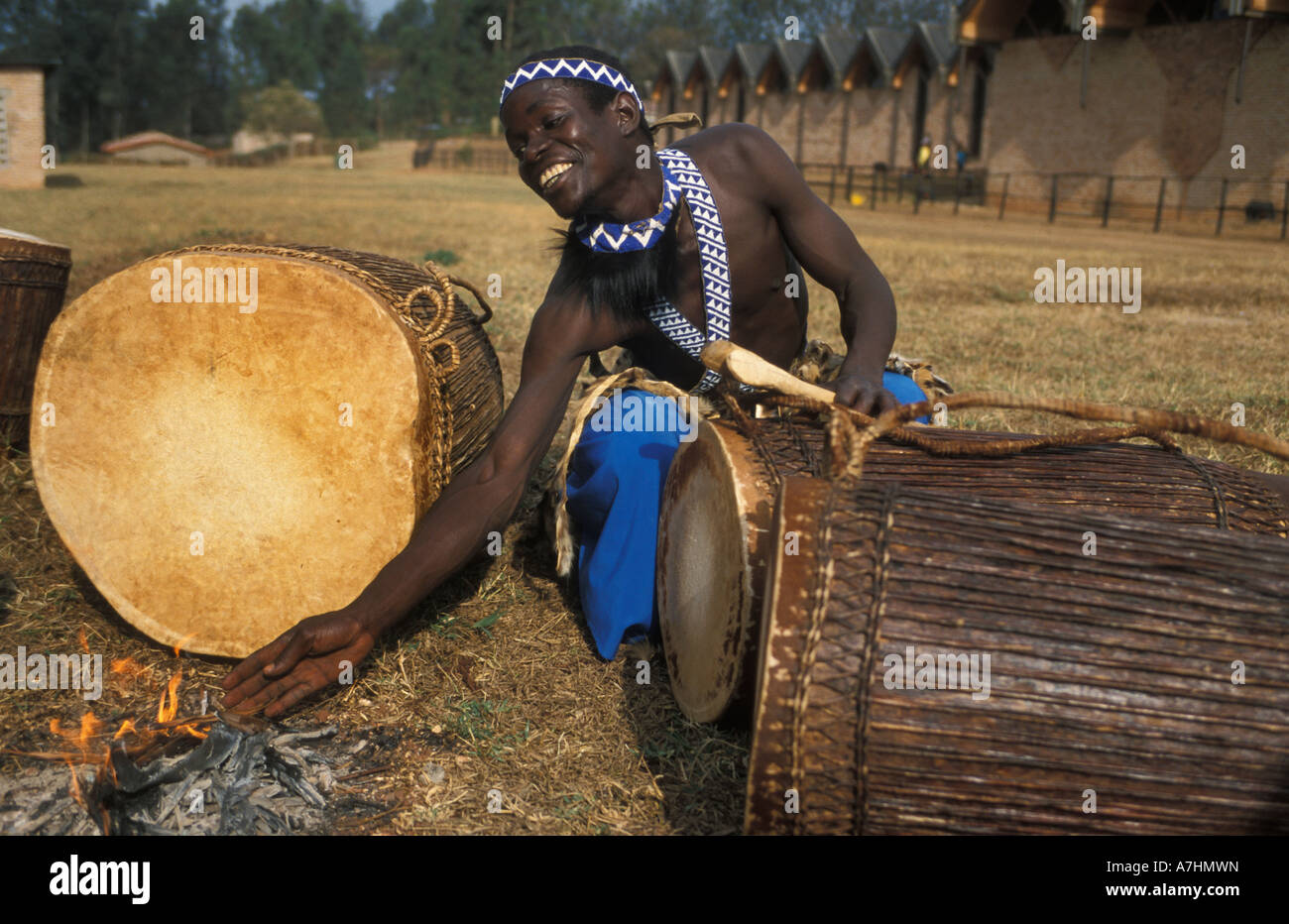 Drummer heating the drums before playing. Intore dance group at the ...