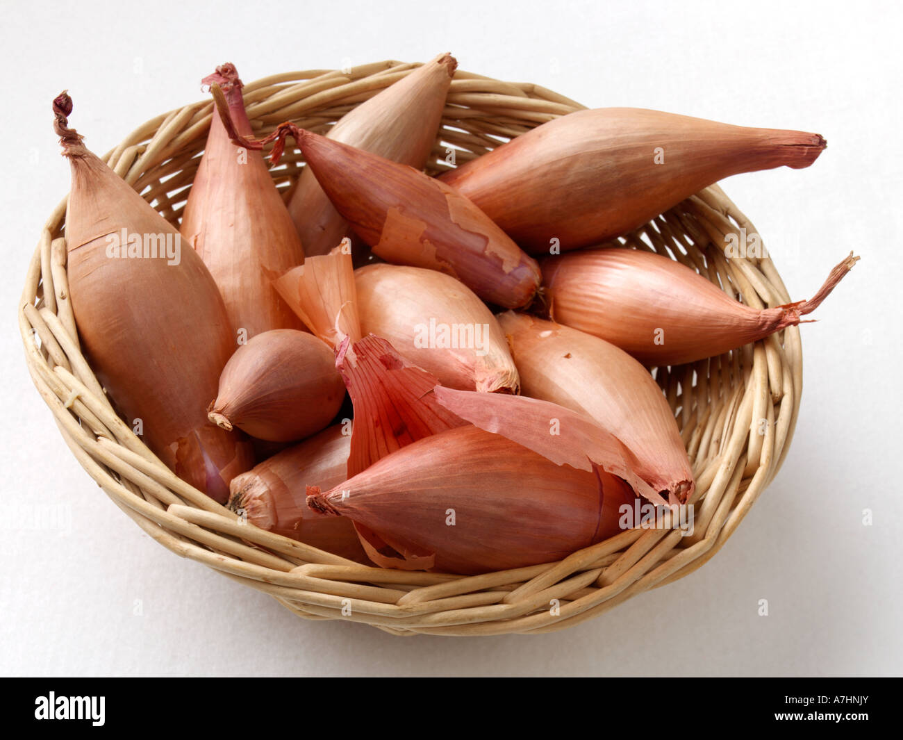 A basket of echalion shallots on a white background Stock Photo - Alamy