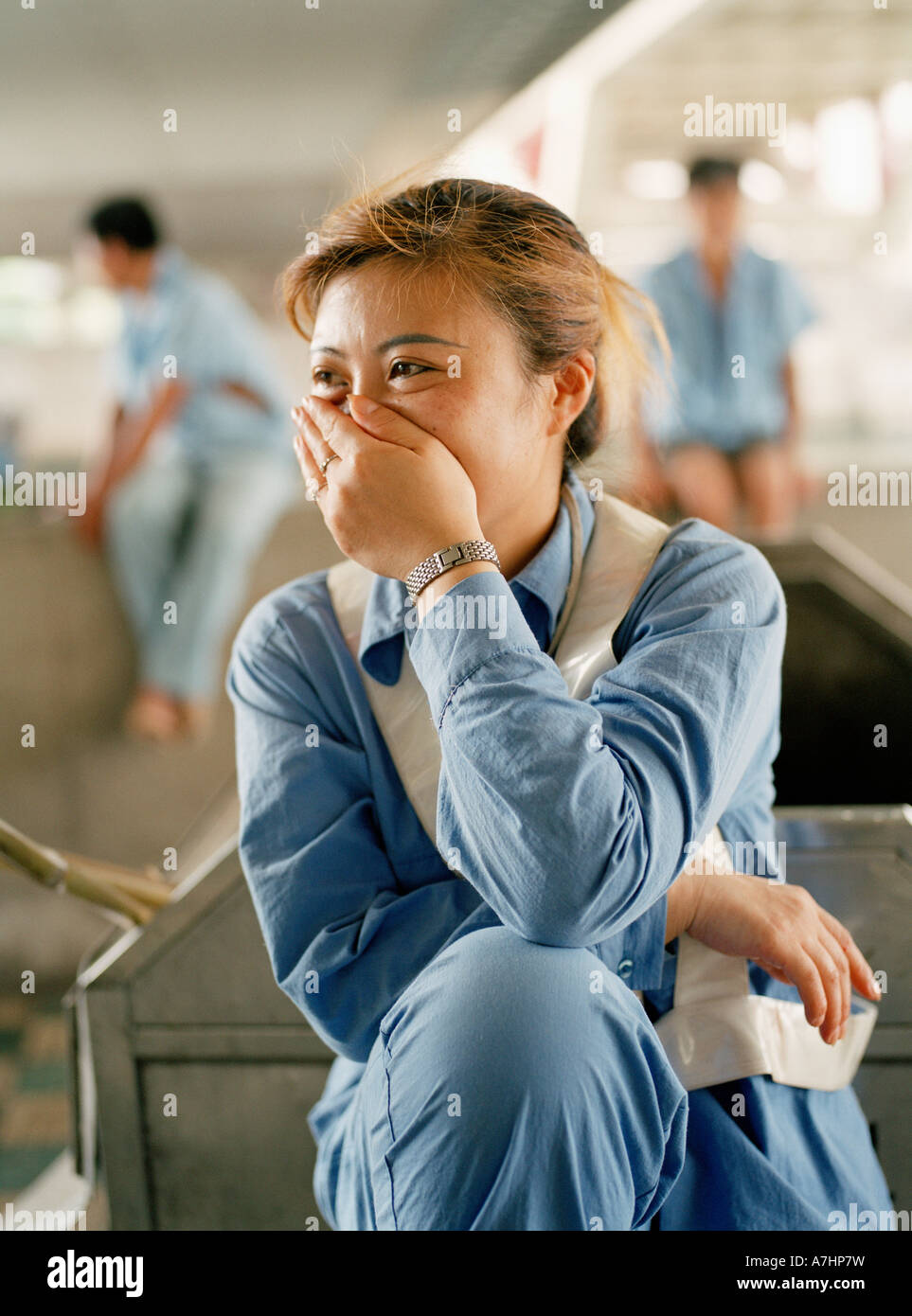 A Chinese street cleaner takes a rest and covers her face Stock Photo ...