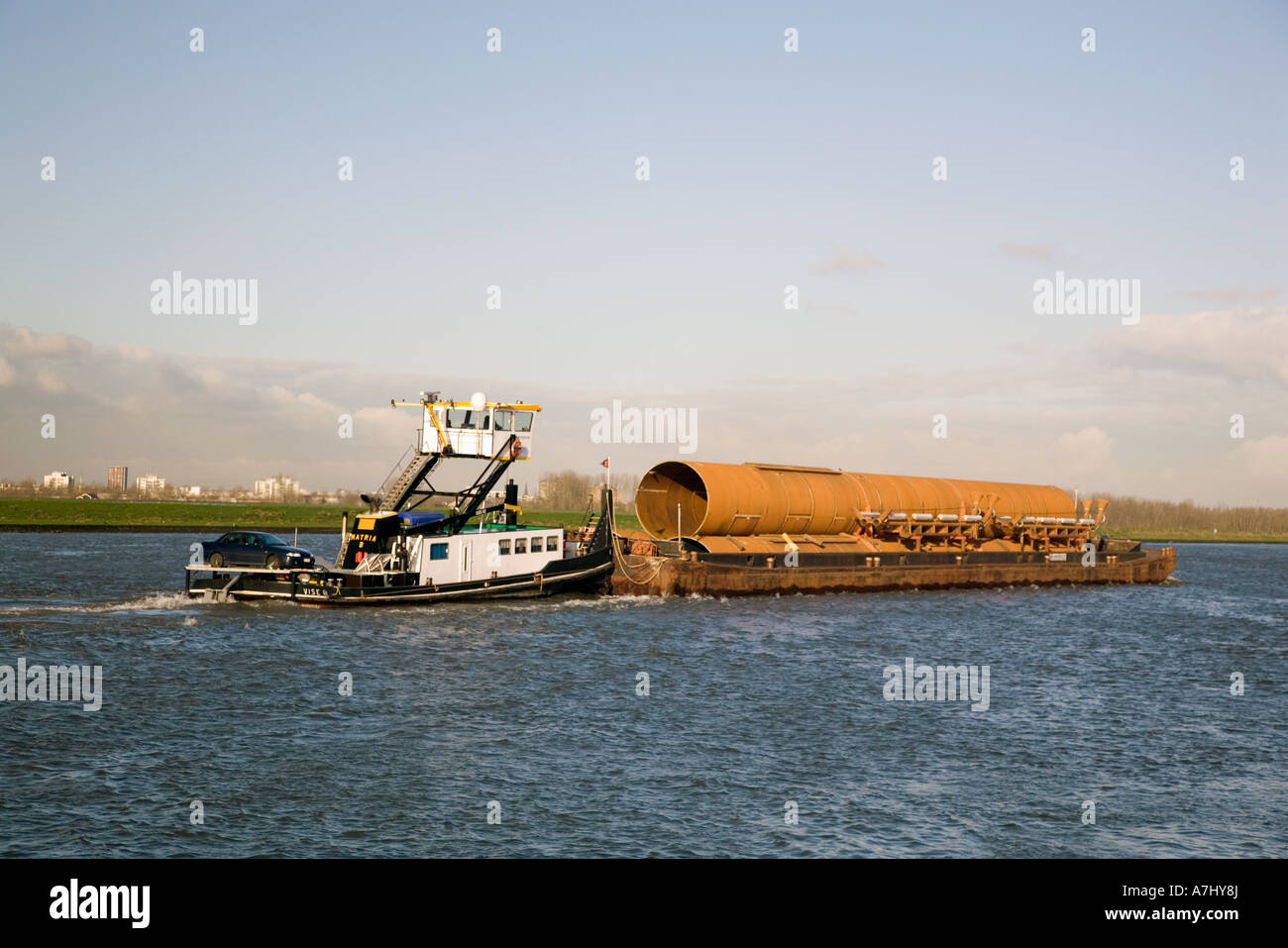 Push boat and barge with a load of huge steel pipes on the river Noord ...