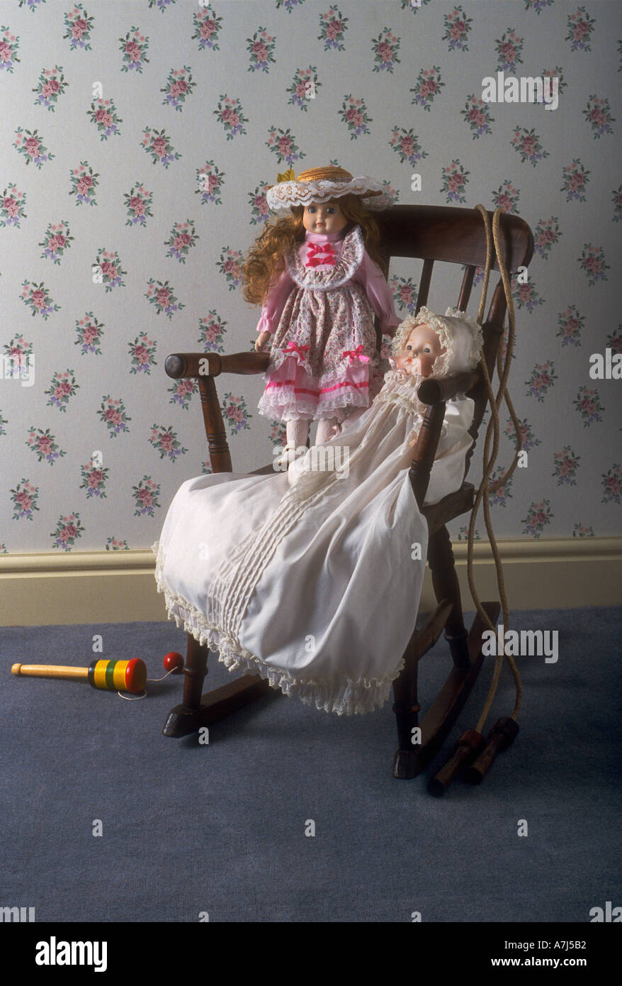 Dolls on a rocking chair Stock Photo - Alamy