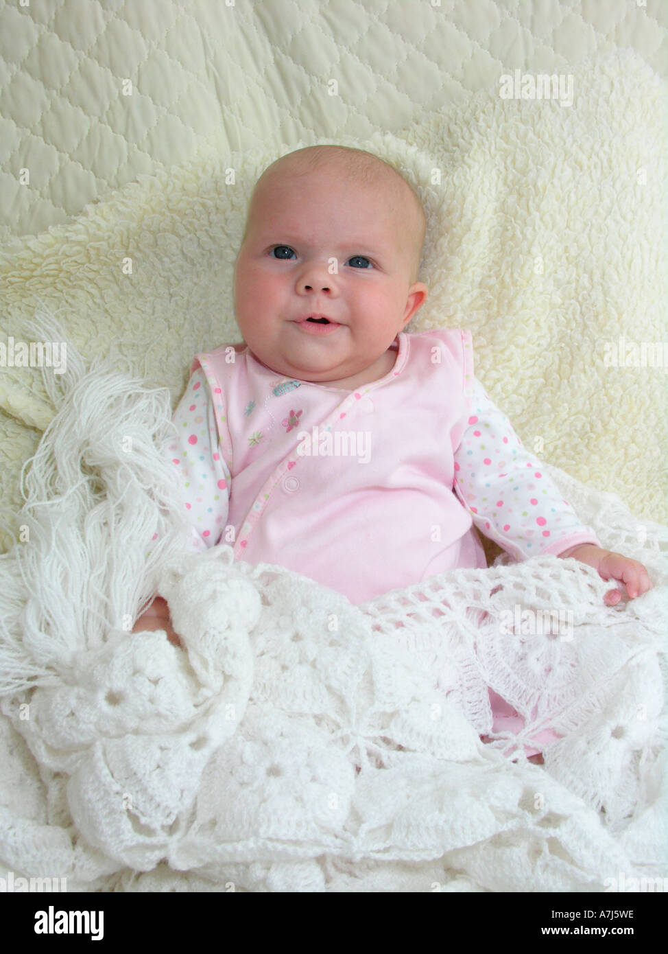 baby girl propped up in blankets and immersed in a pretty shawl Stock ...