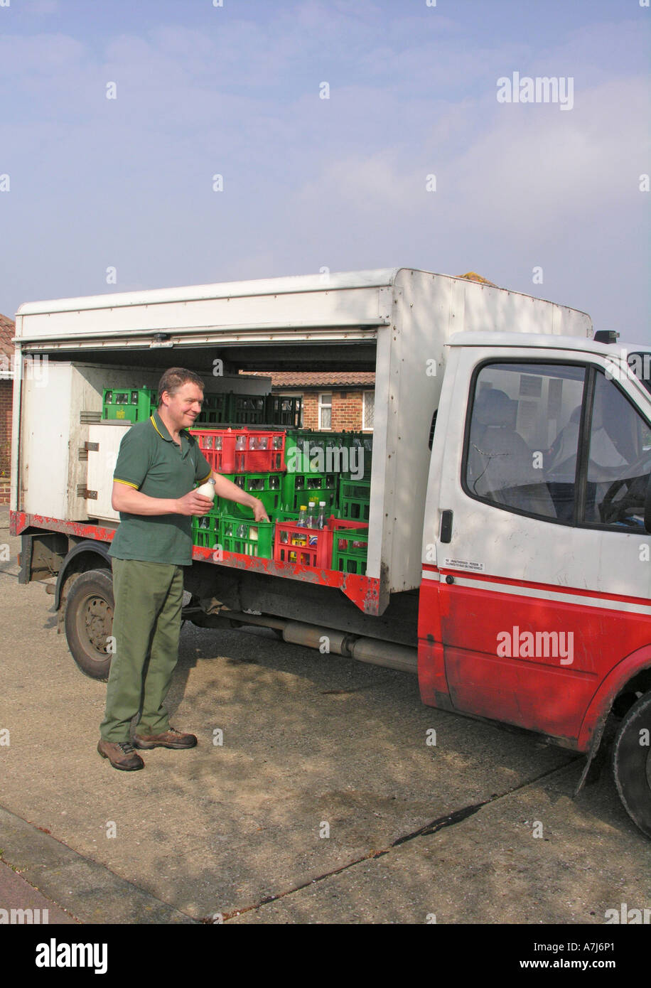 milkman on round with a motorised driven float Stock Photo - Alamy