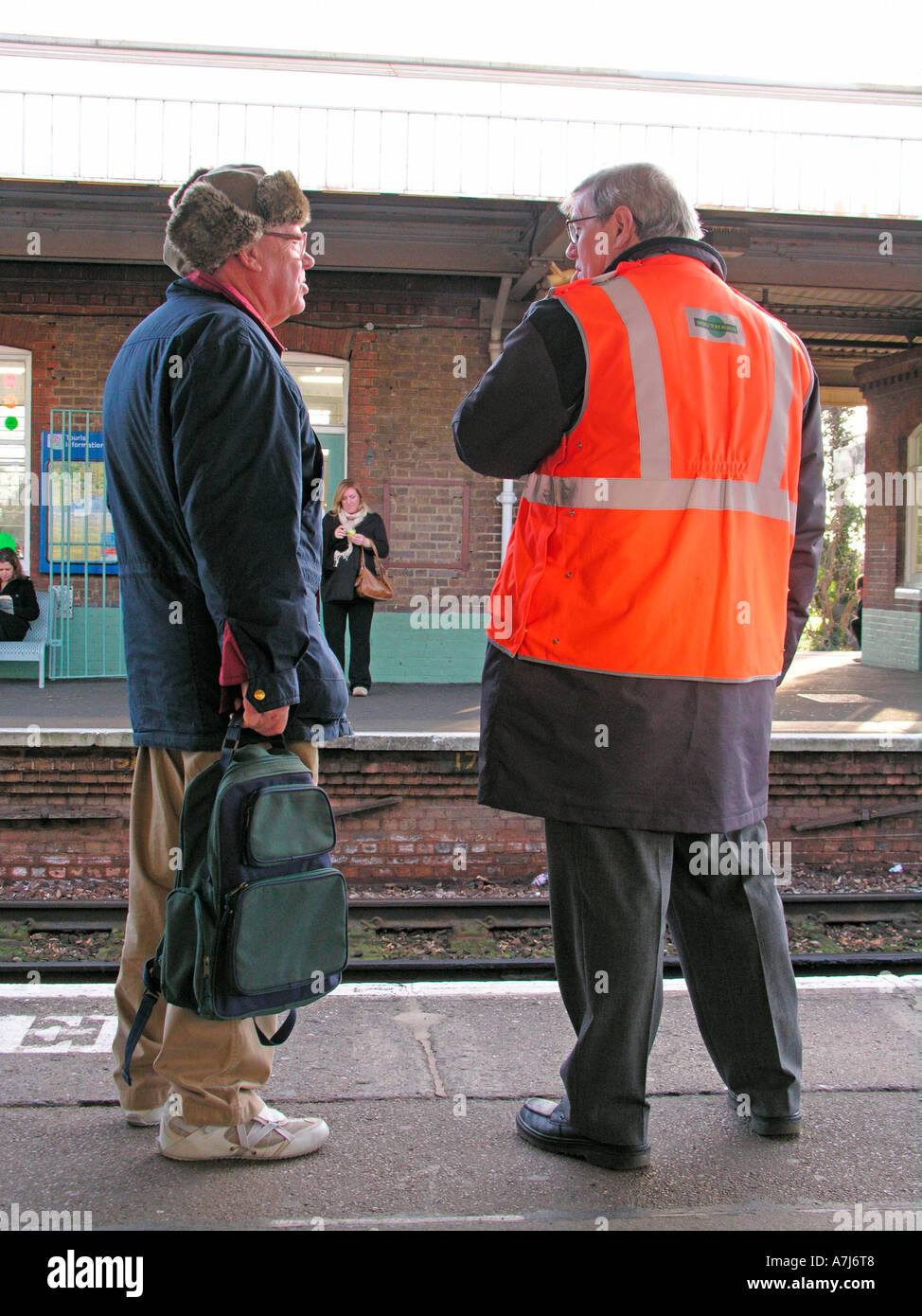 elderly man talking to station railway worker porter asking for ...