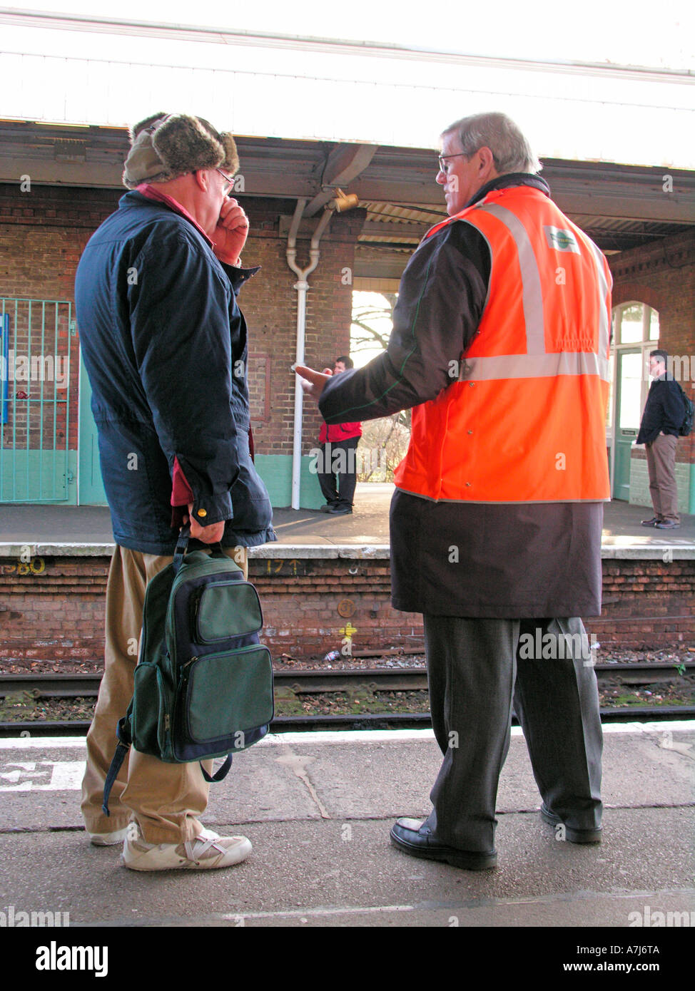 elderly man talking to station railway worker porter asking for ...