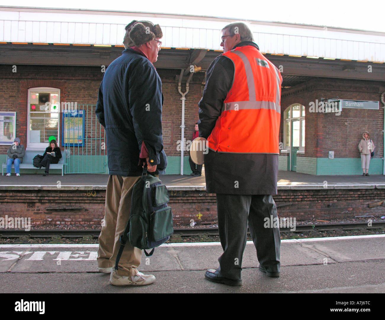 elderly man talking to station railway worker porter asking for ...
