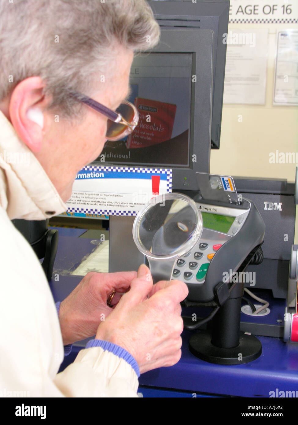 elderly woman with visual disability using a magnifying glass to help ...