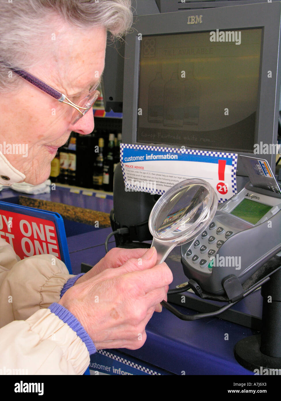 elderly woman with visual disability using a magnifying glass to help ...