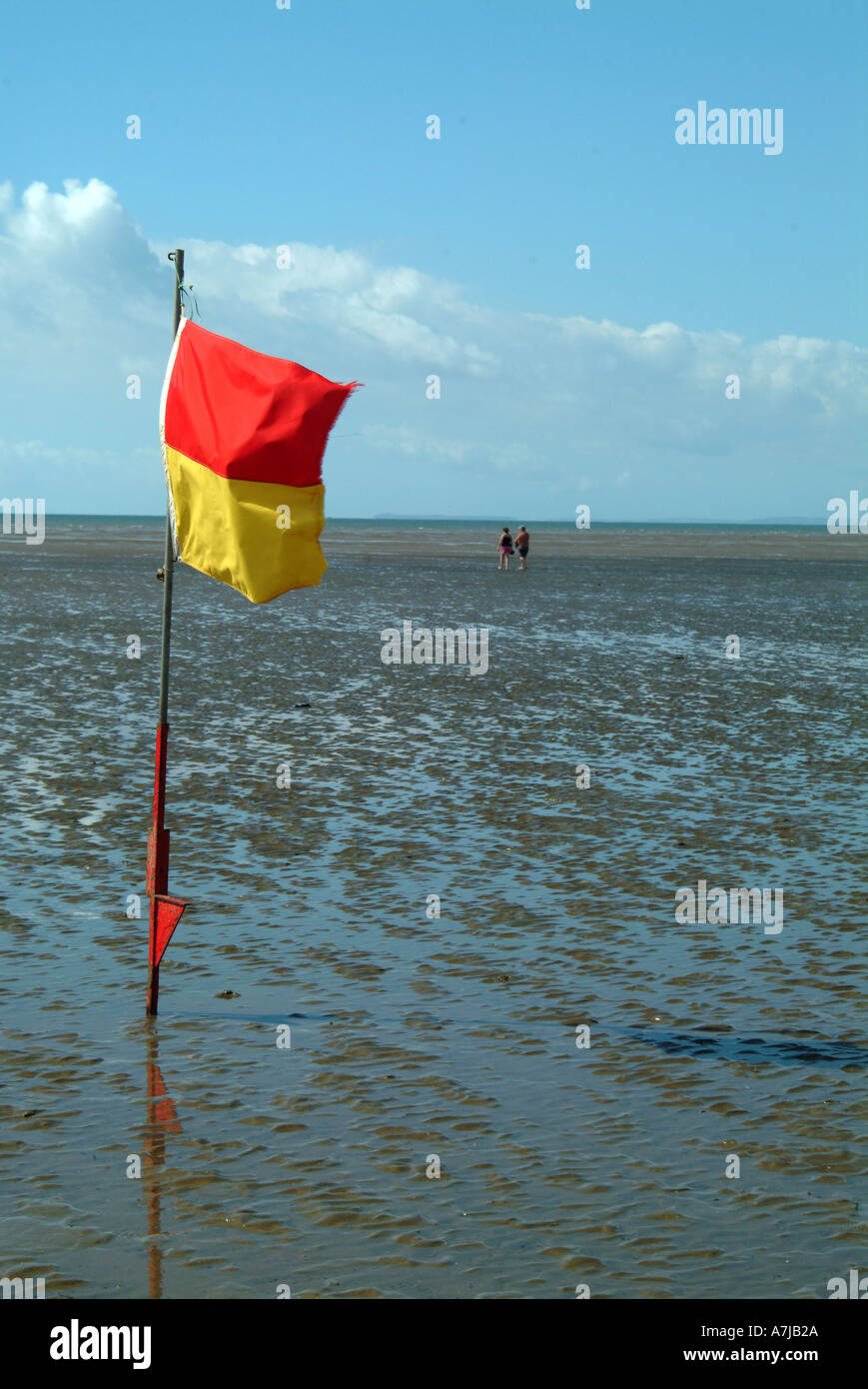 Red and yellow swimming warning flag on beach at low tide Pembrey ...
