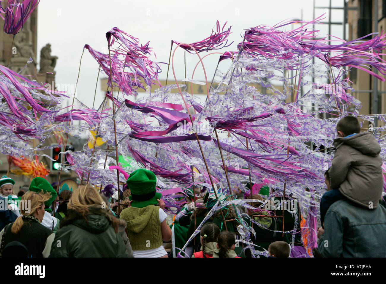 parade goers waving colourful purple ribbons walking down High Street ...