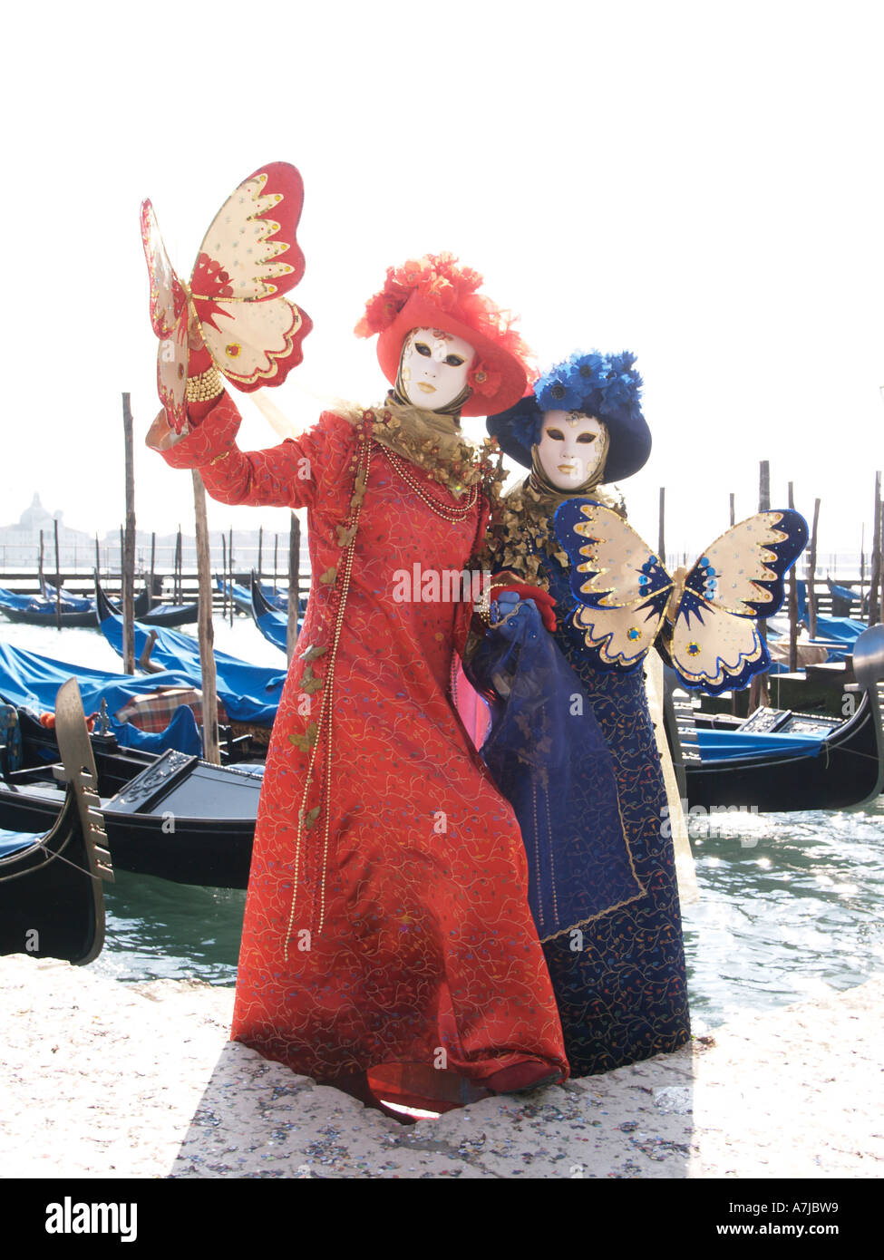 two women in red and blue costumes on quayside Venice carnival Stock ...