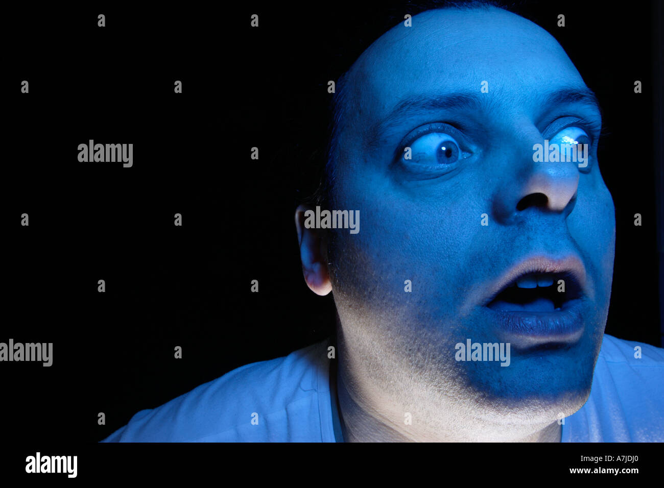 fearful male face in blue light Stock Photo - Alamy