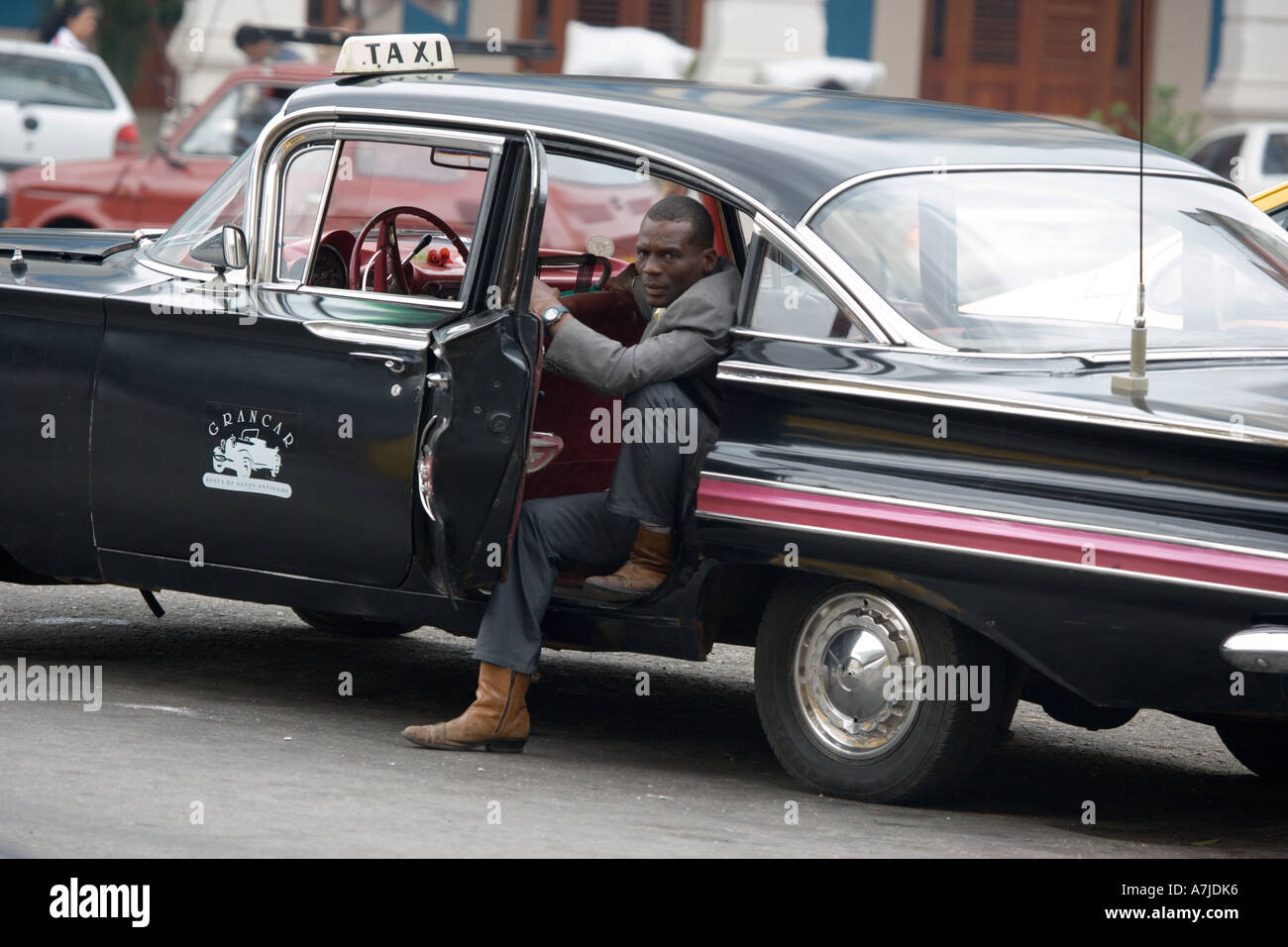Cuban driver in his Classic American Fifties tourists-only taxi awaits ...