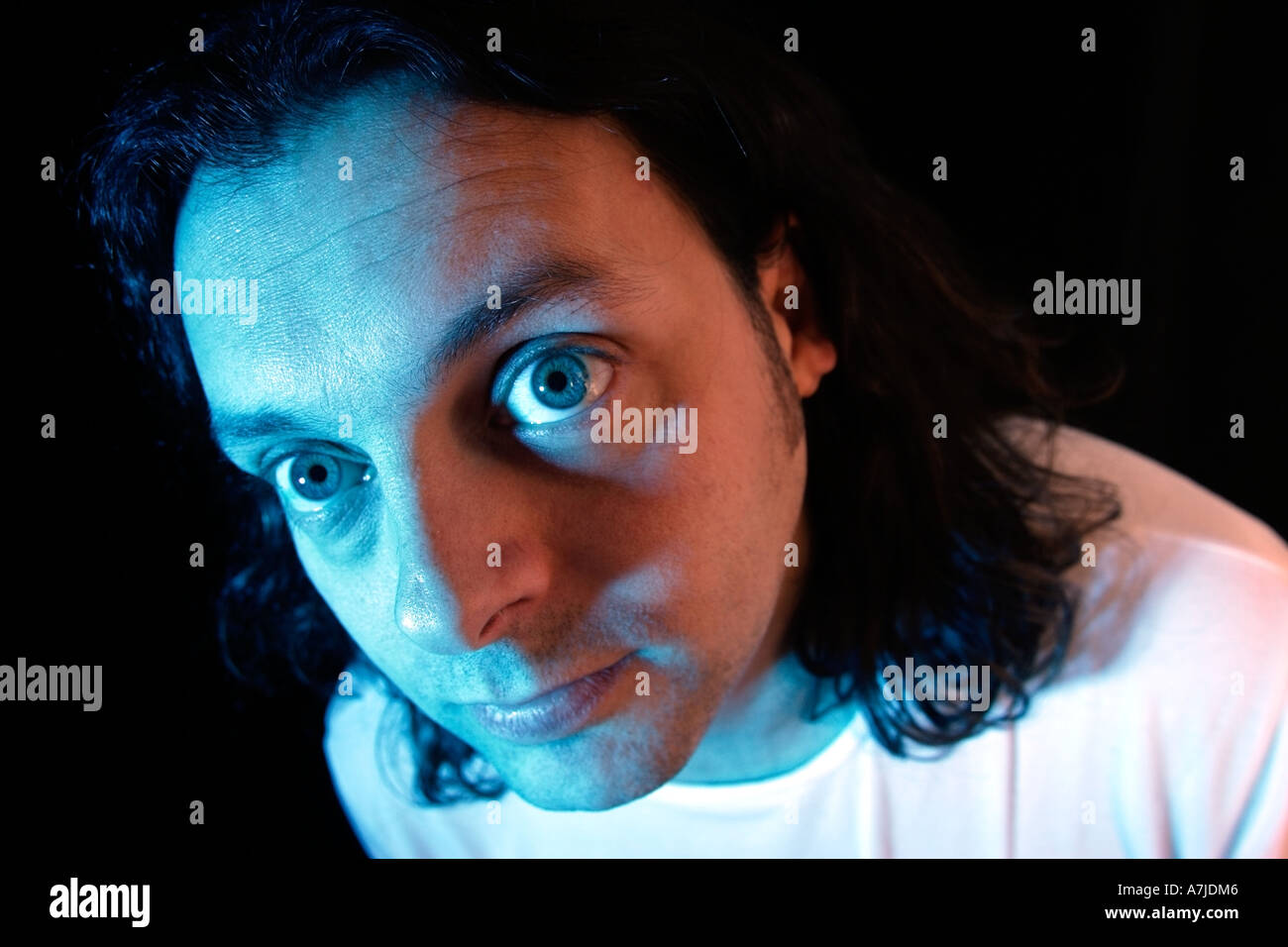 Male face with wide-eyed expression in black room Stock Photo - Alamy
