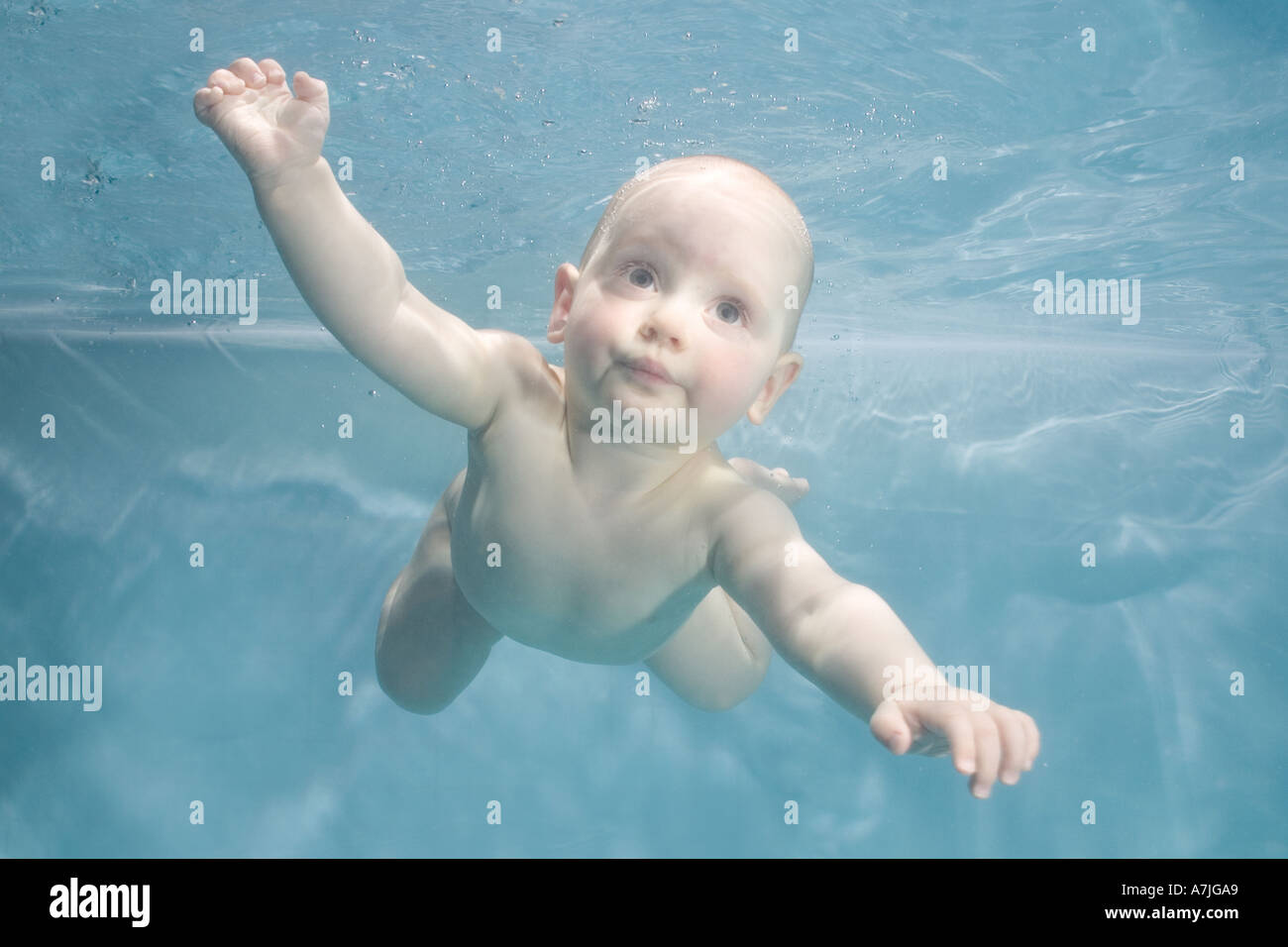 Baby underwater in pool with arms outstretched on blue background Stock ...