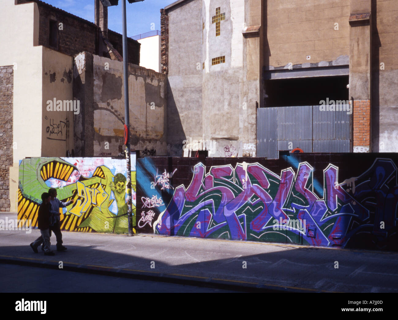 Boys walk in front of graffiti in Barcelona Stock Photo - Alamy