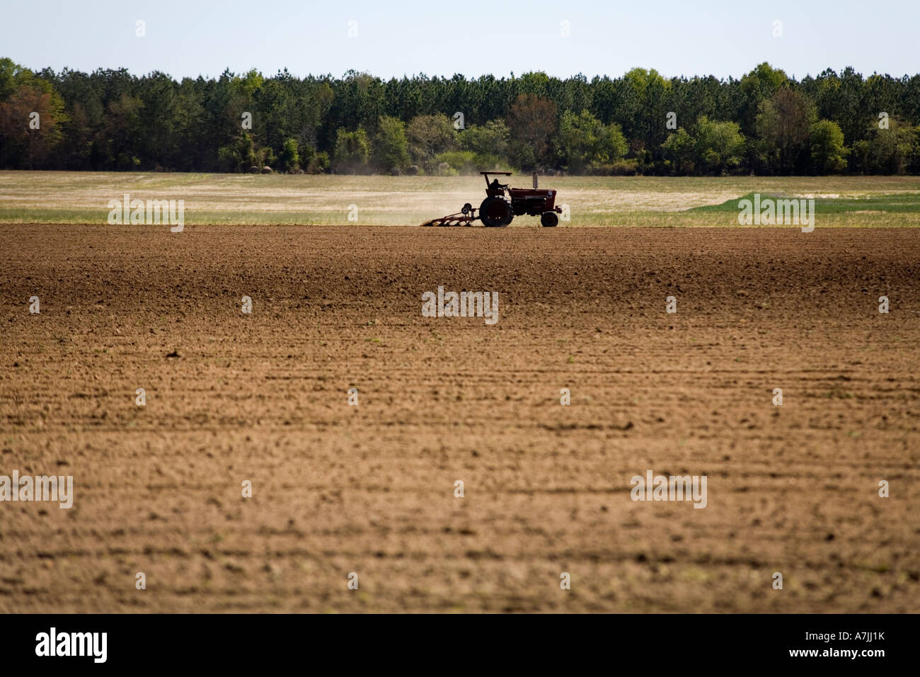 Tractor plowing dirt field Stock Photo - Alamy