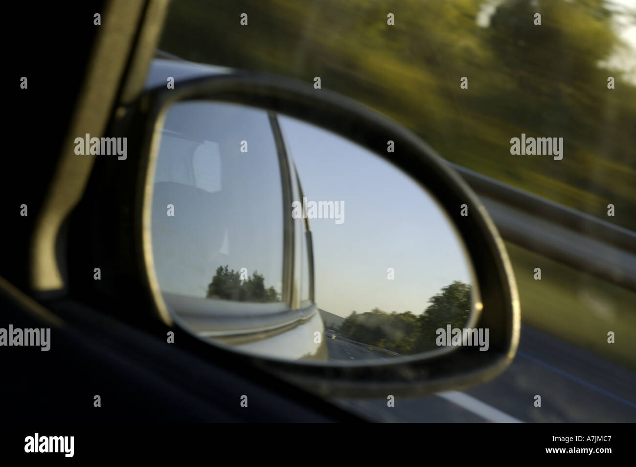 Left side rear view mirror of a speeding car on a highway Stock Photo ...