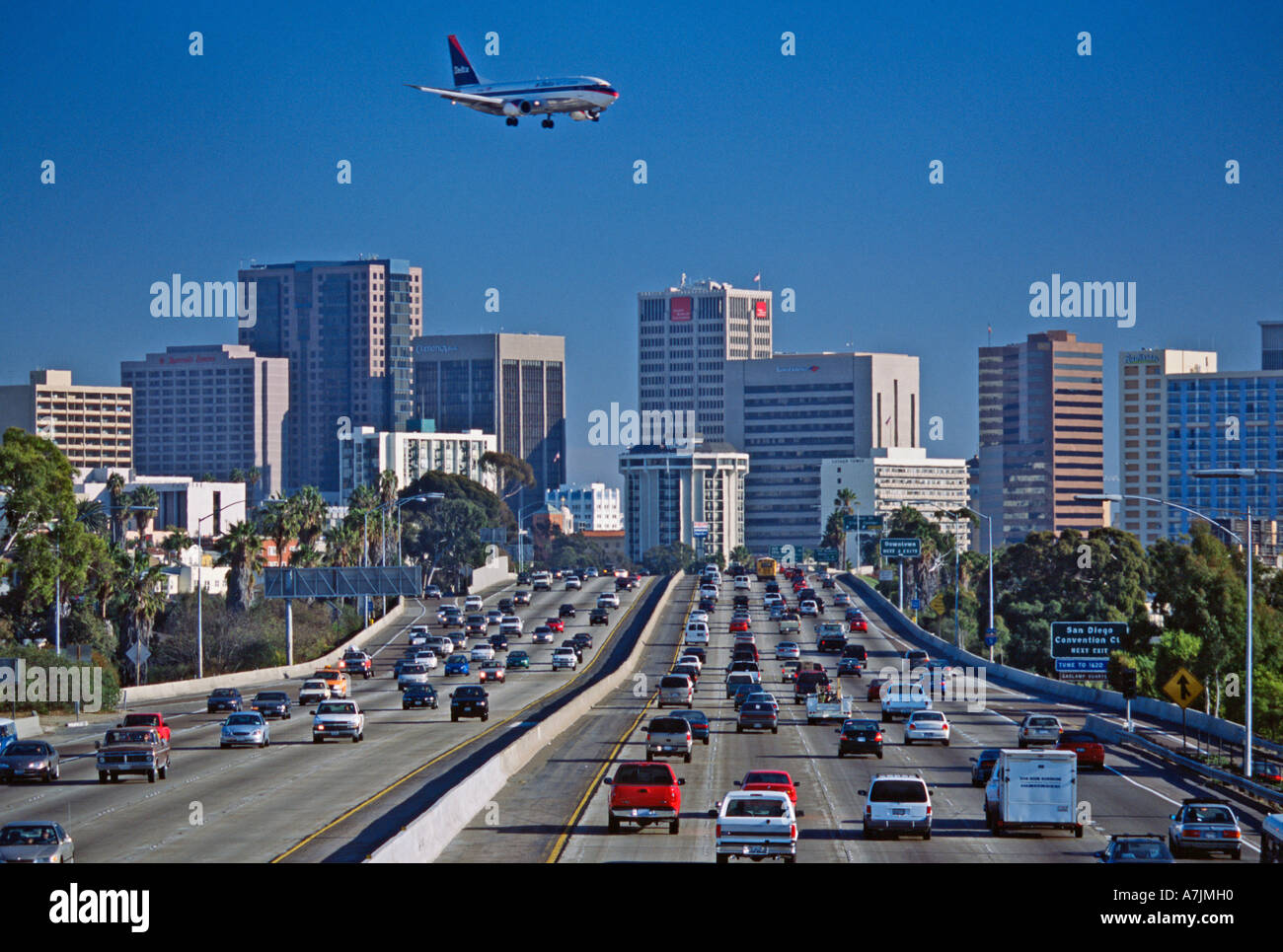 Jet airliner flying over commuter trafic on Interstate highway 5 in San ...